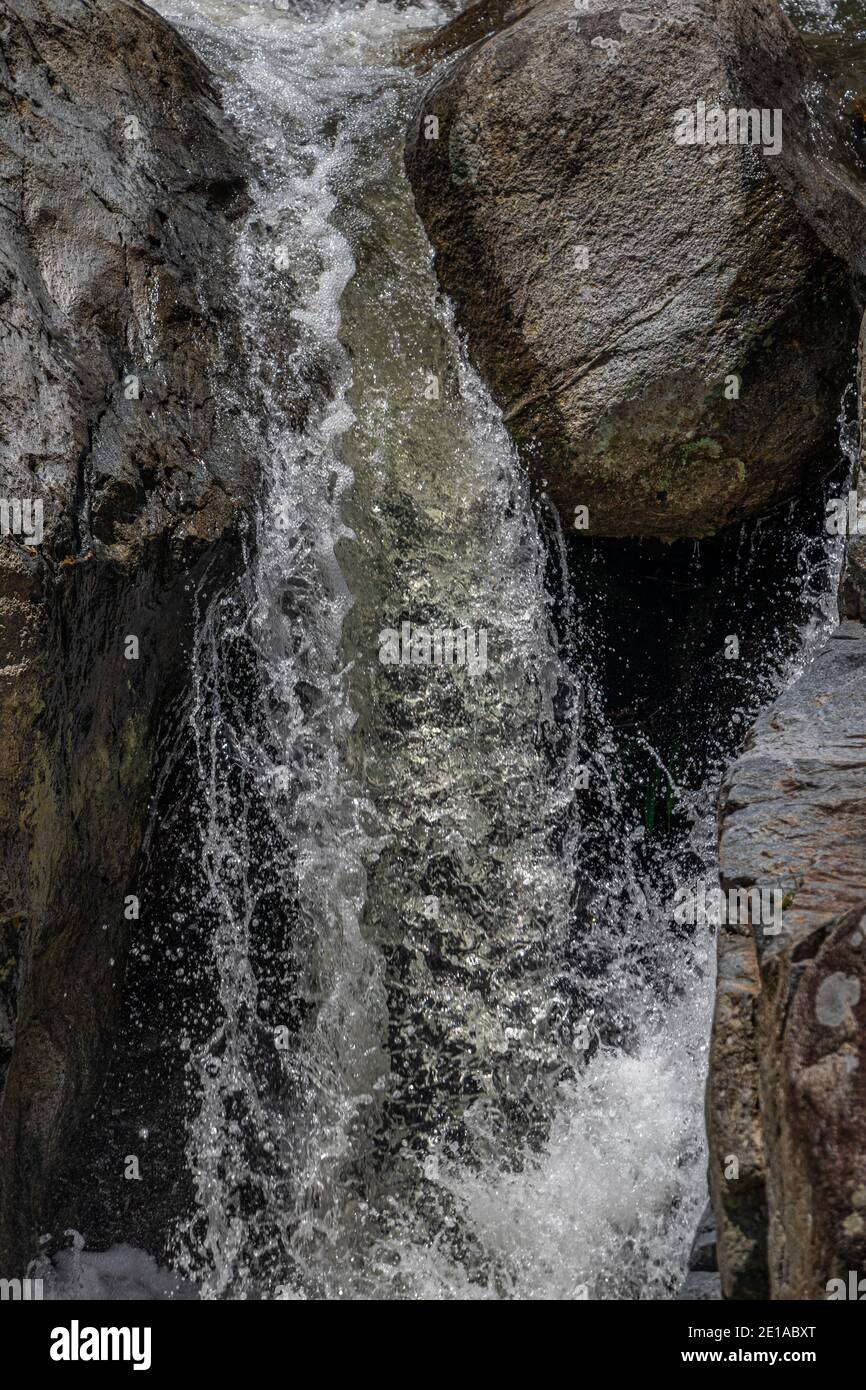 Water flowing between giant rocks creating natural waterfalls Stock ...