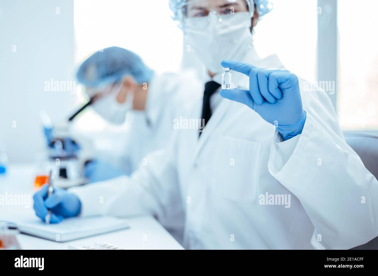 background image of a scientist recording test results in a lab log ...