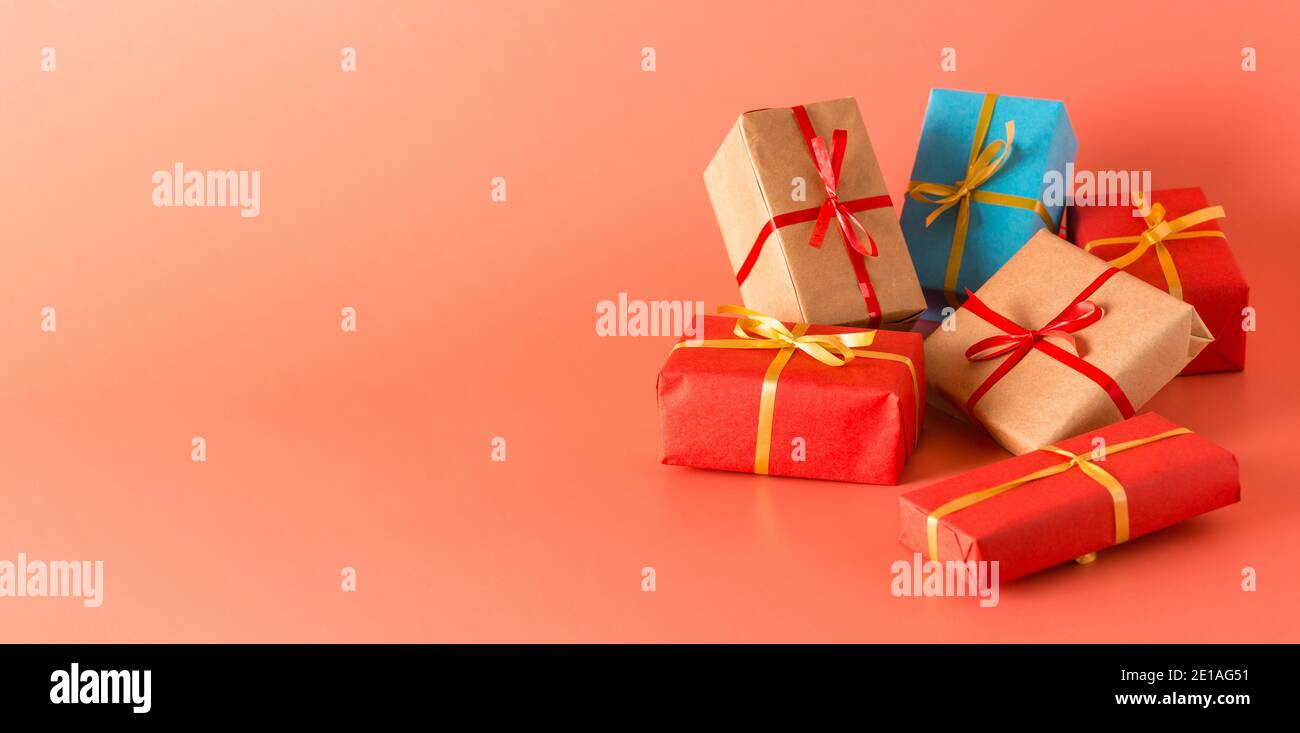 Lots of gifts wrapped in paper and tied with a ribbon. Pink background ...