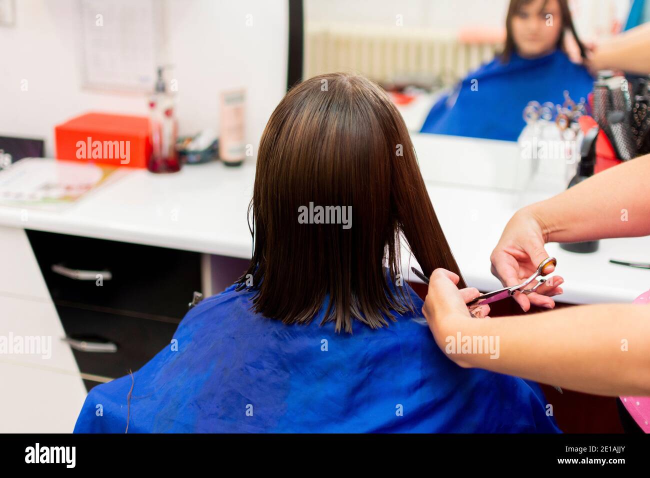 Professional female hairdresser cutting girl's hair in salon Stock ...
