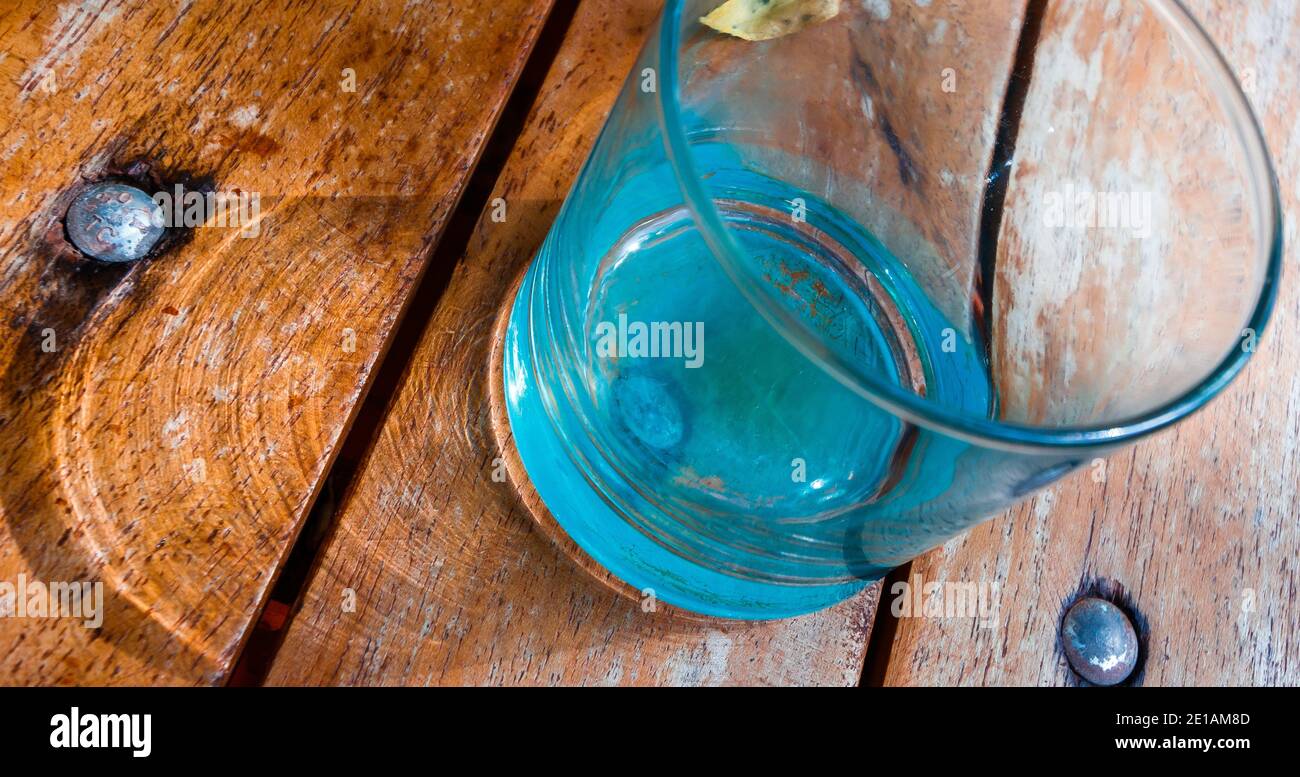 Extreme detail of a water glass on a rustic wood table casting some ...