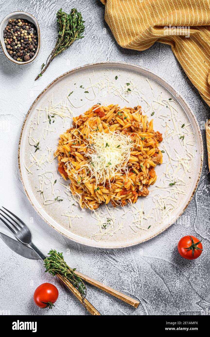 Bolognese pasta, risone with ground beef. White background. Top view ...