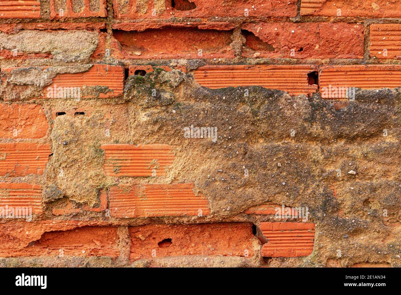 Fragment of an old damaged weathered brick wall with rot and mold close ...