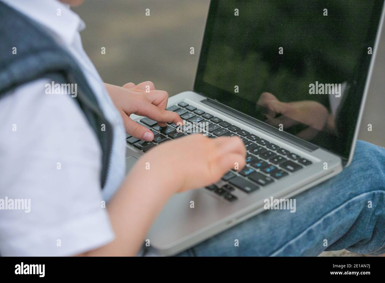 boy with notebook near school with a book online learning on a blurred ...