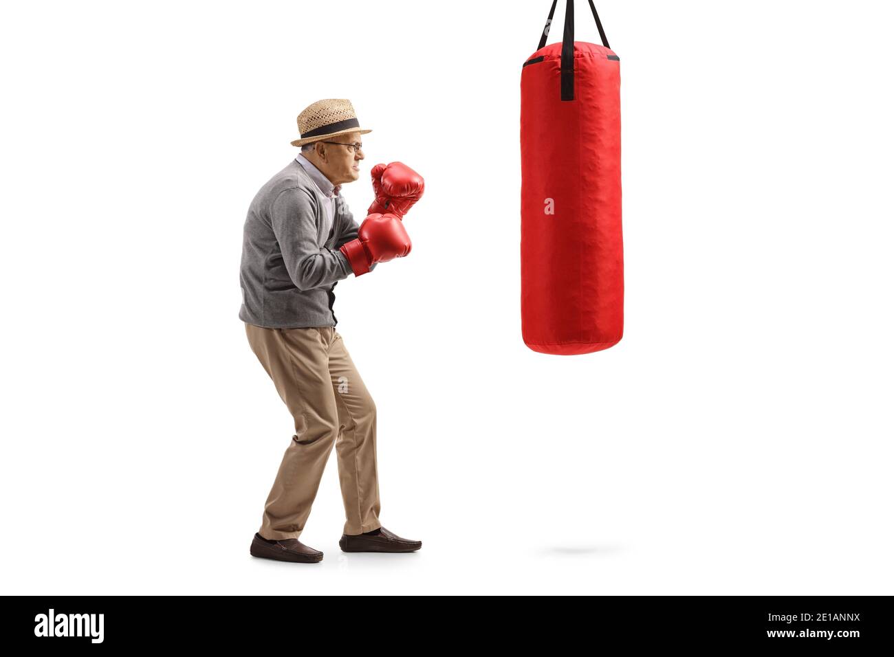 Full length profile shot of an elderly man exercising box and punching ...