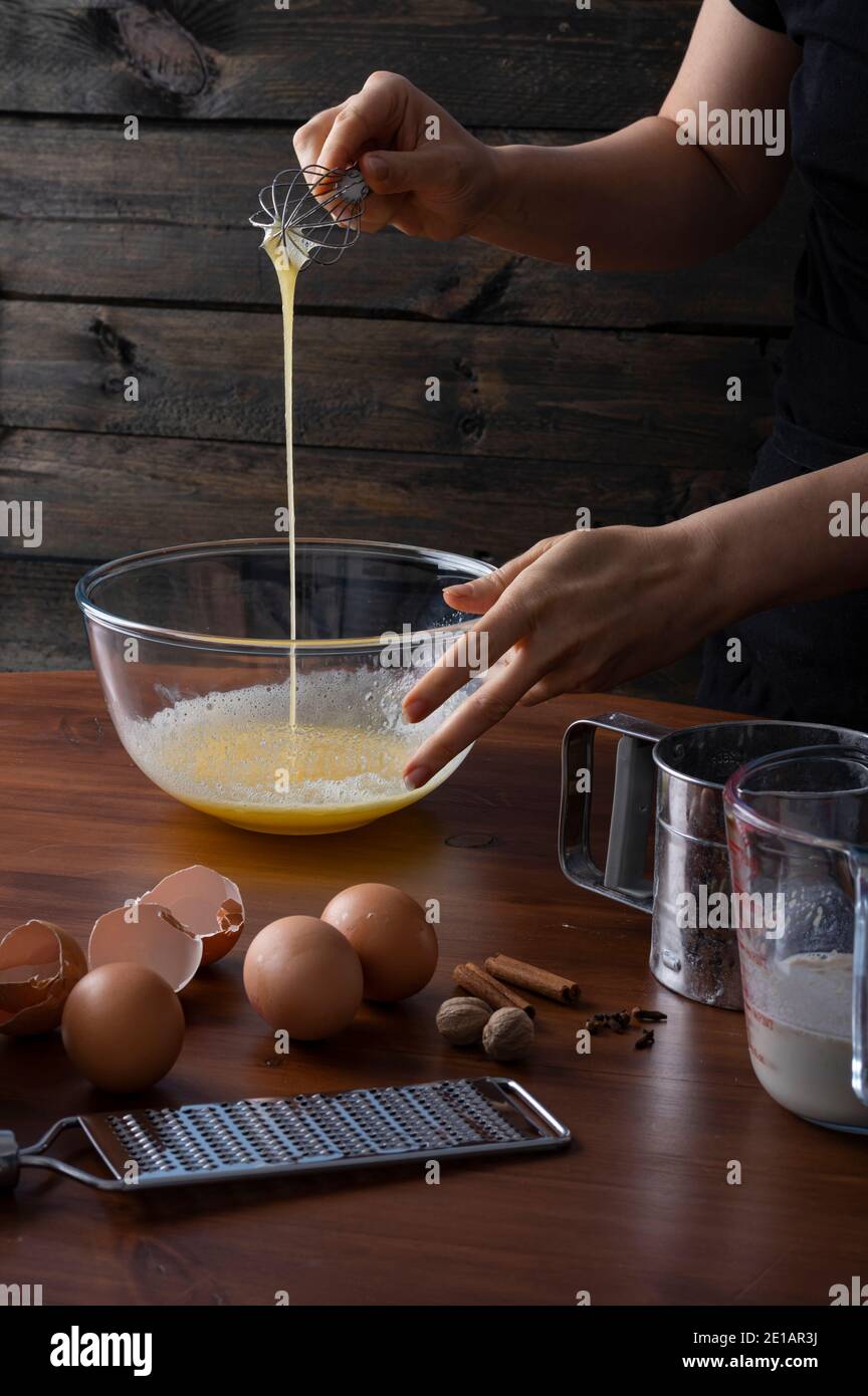 A woman whisking eggs and spices in a bowl at a cottage kitchen Stock ...