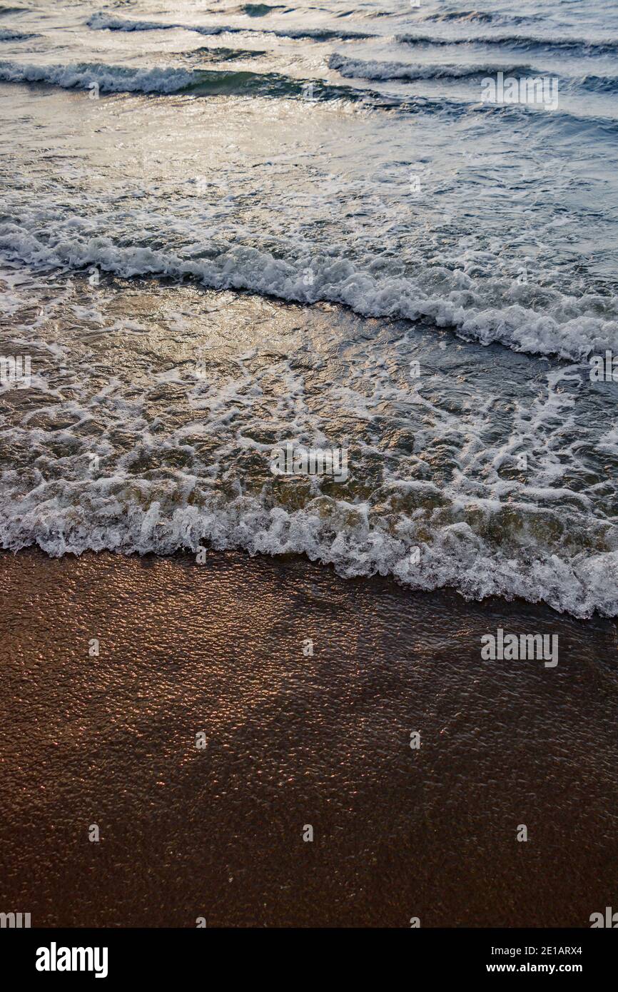 Beautiful landscape from a moving ocean waves reaching gently the sandy ...