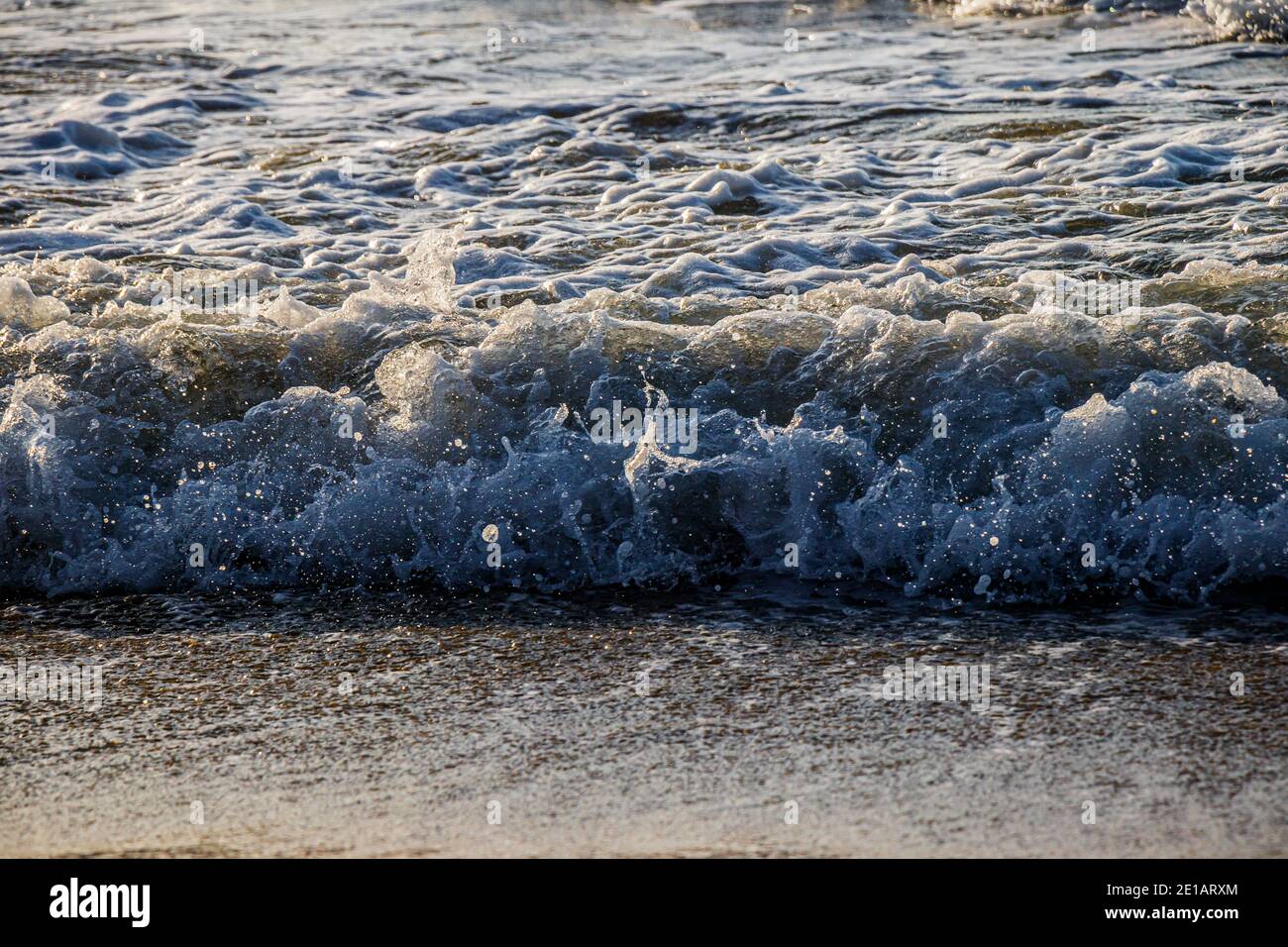Beautiful landscape from a moving ocean waves reaching gently the sandy ...