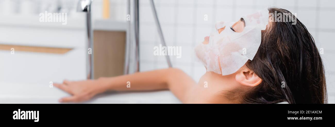 young woman in face mask relaxing while taking bath, blurred background ...