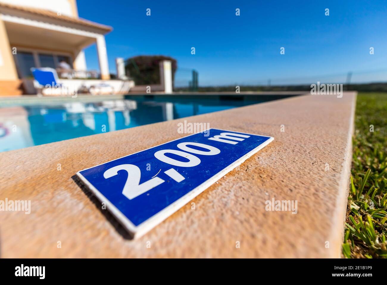 blue plastic plate at the edge of a swimming pool indicating a depth of ...