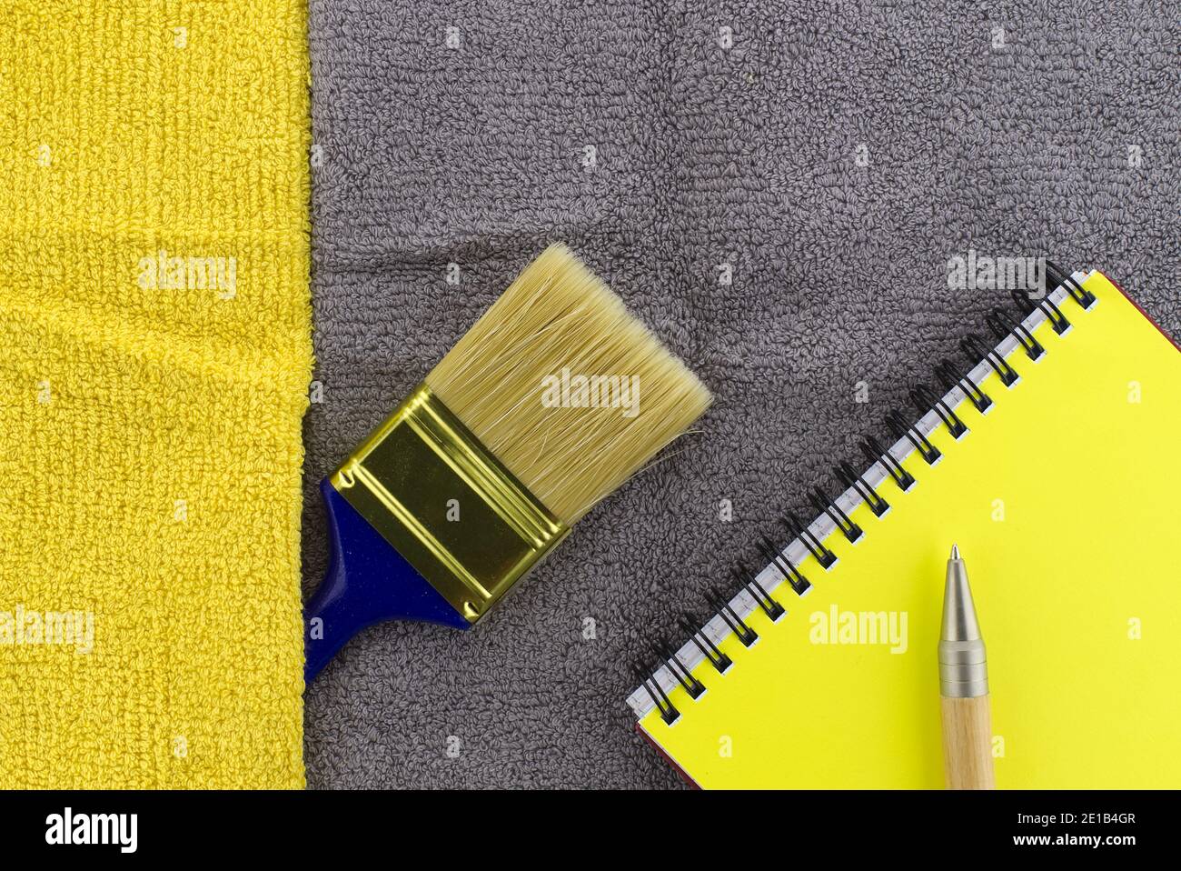 Colorful yellow and grey themed still life with clean paintbrush and ...