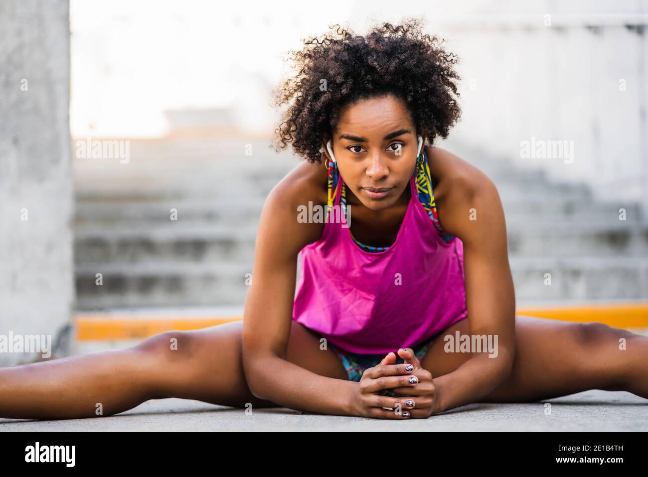 Afro athlete woman stretching legs before exercise Stock Photo - Alamy