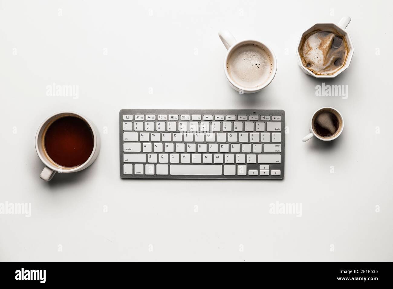 Computer keyboard and cups of coffee isolated on white background Stock ...