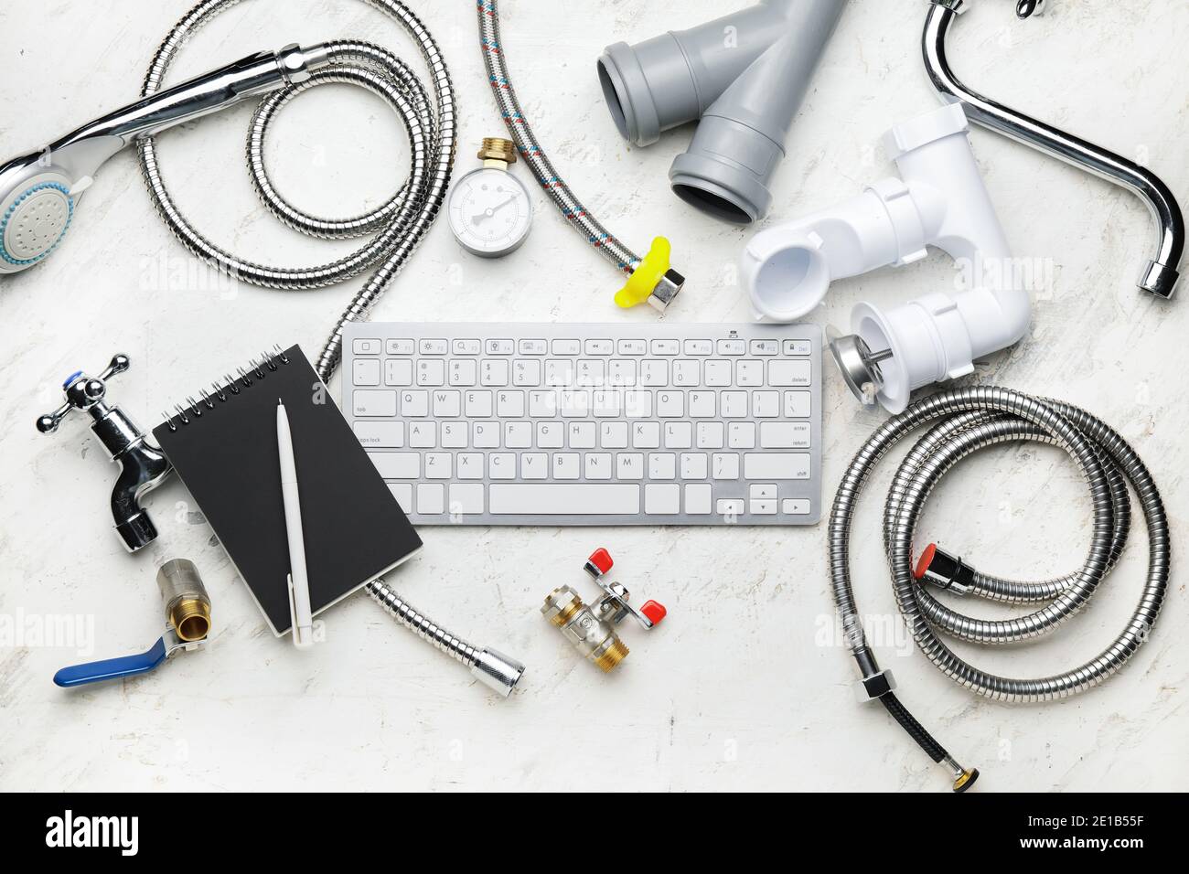Plumbing items and computer keyboard on light background Stock Photo ...