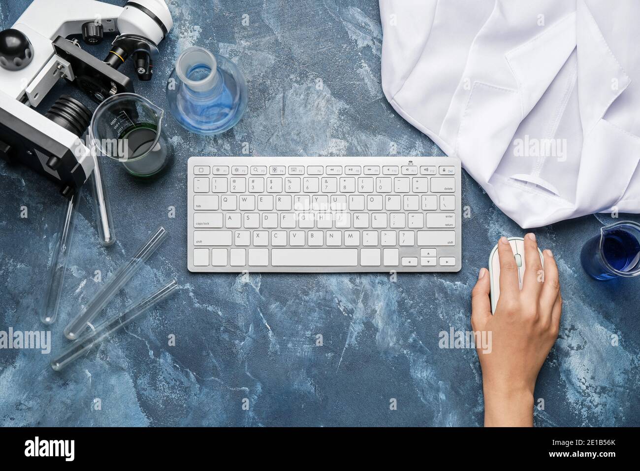 Female hand with computer keyboard, microscope and mouse on color ...