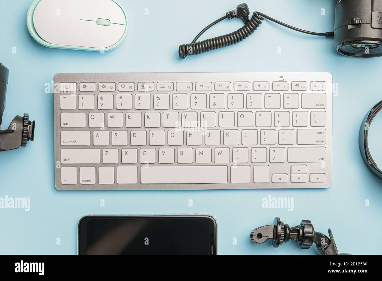 Computer keyboard and modern photographer's equipment on color table ...