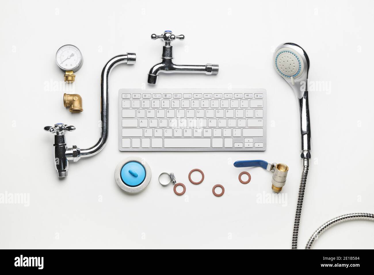 Composition with plumber's items and computer keyboard on white ...