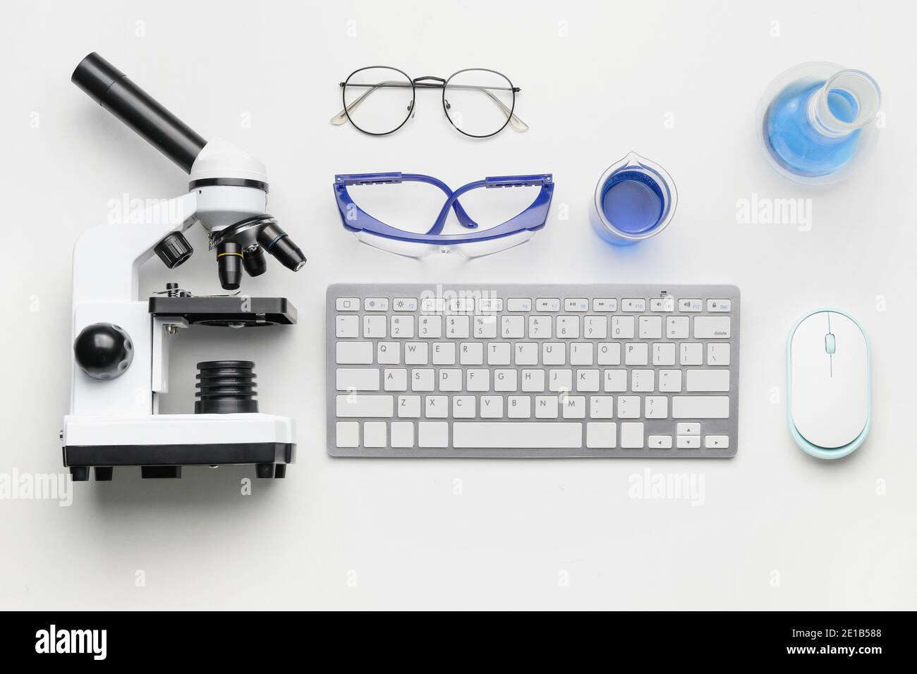 Composition with computer keyboard, mouse and microscope on white ...
