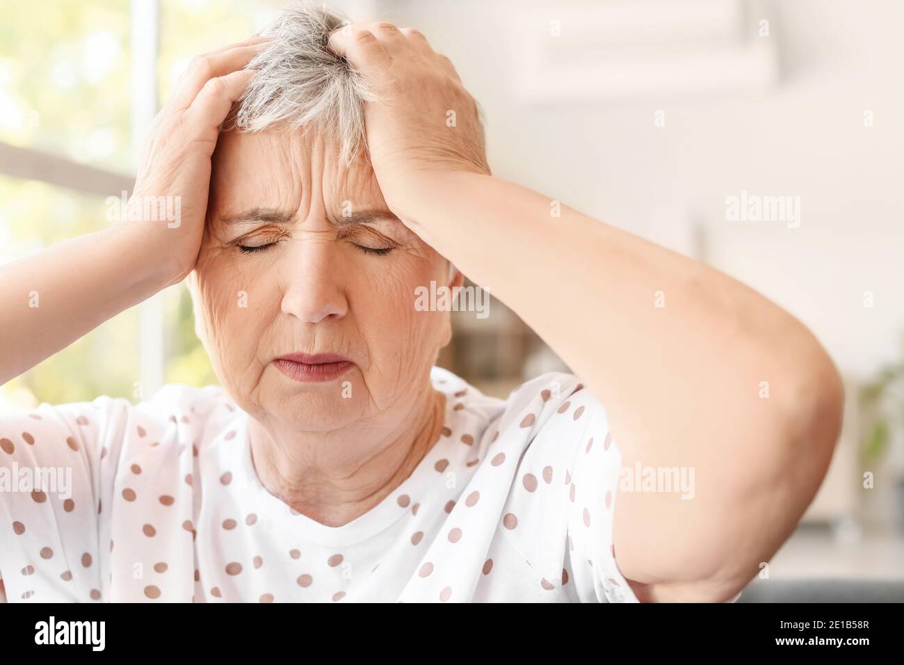 Stressed senior woman suffering from headache Stock Photo - Alamy