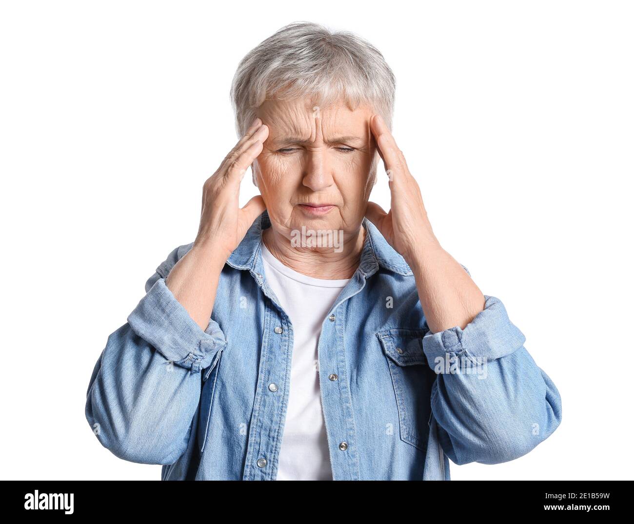 Stressed senior woman suffering from headache isolated on white ...