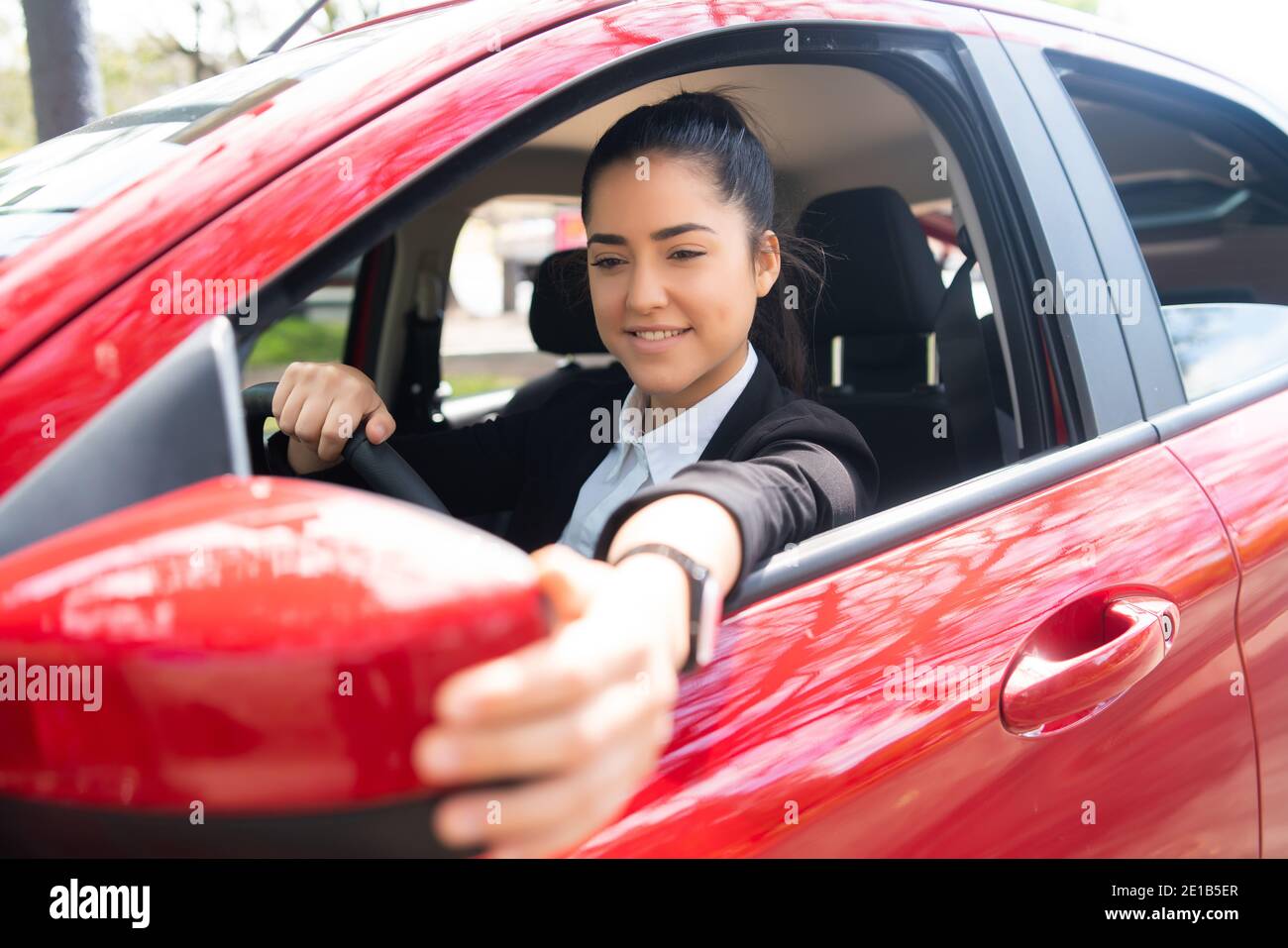 Woman moving rear view wing mirror in car Stock Photo - Alamy
