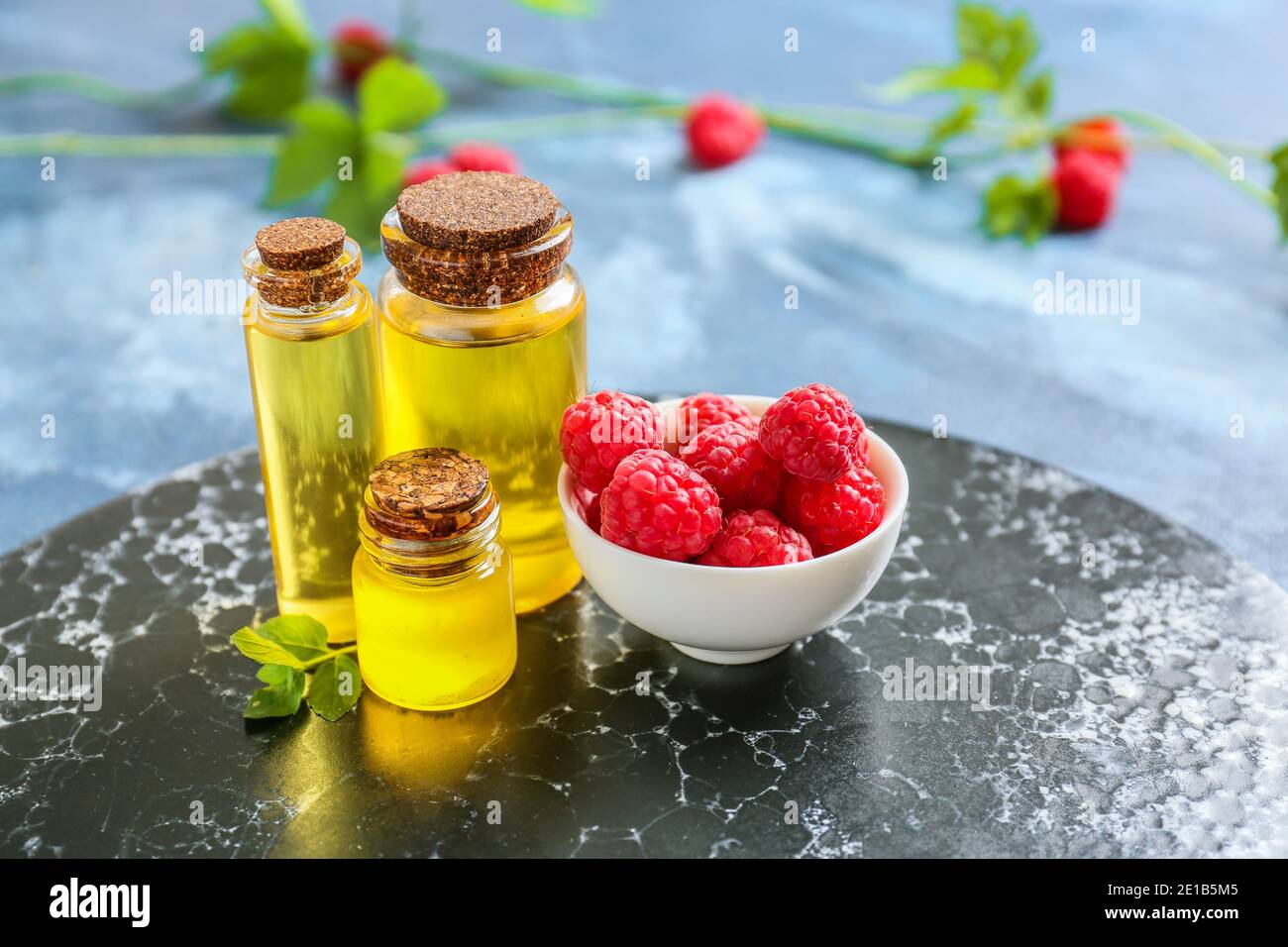 Bottles of raspberry essential oil on table Stock Photo - Alamy