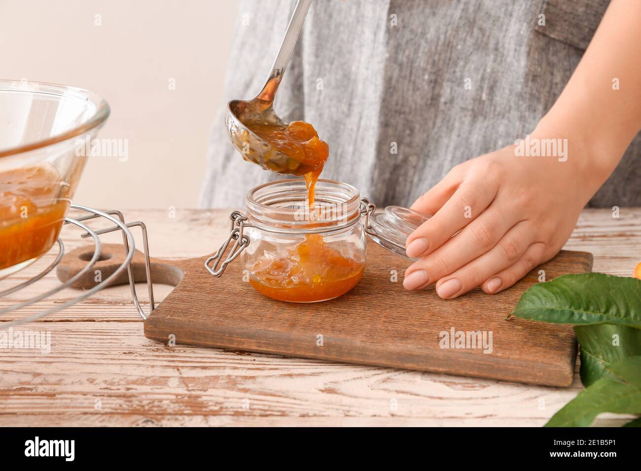 Woman pouring tasty peach jam into jar Stock Photo - Alamy