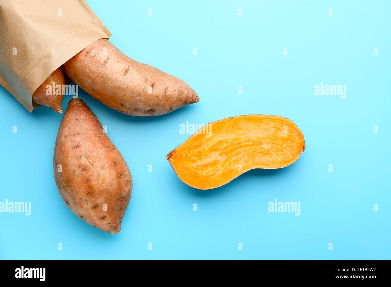 Paper bag with fresh sweet potatoes on color background Stock Photo - Alamy