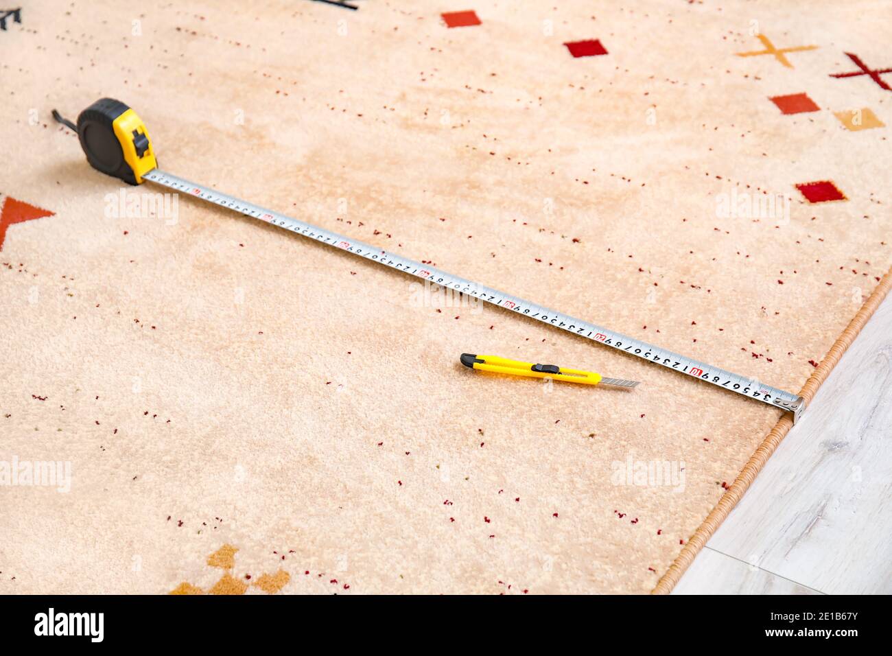 Measuring tape and knife on carpet Stock Photo - Alamy