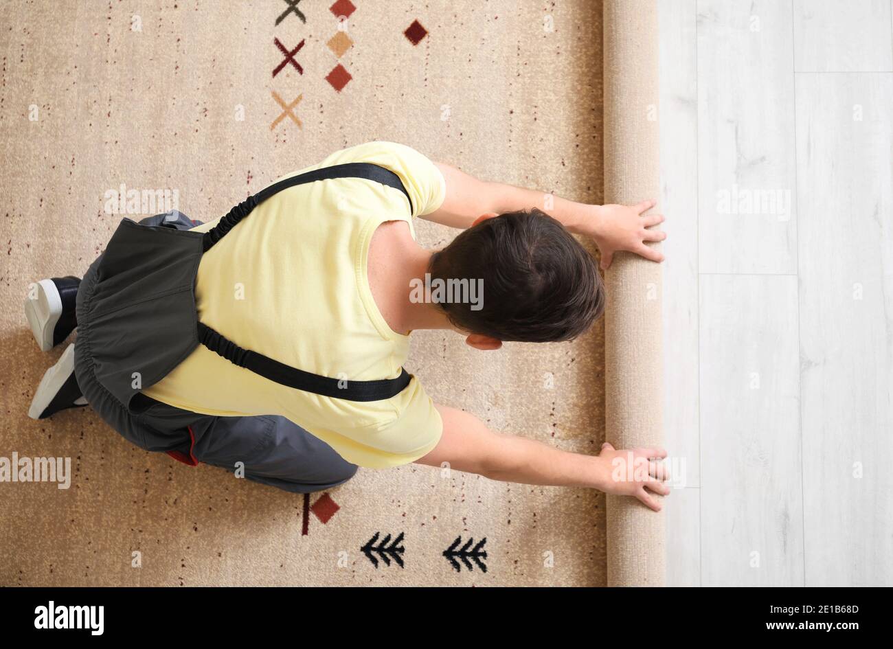 Male worker rolling carpet hi-res stock photography and images - Alamy