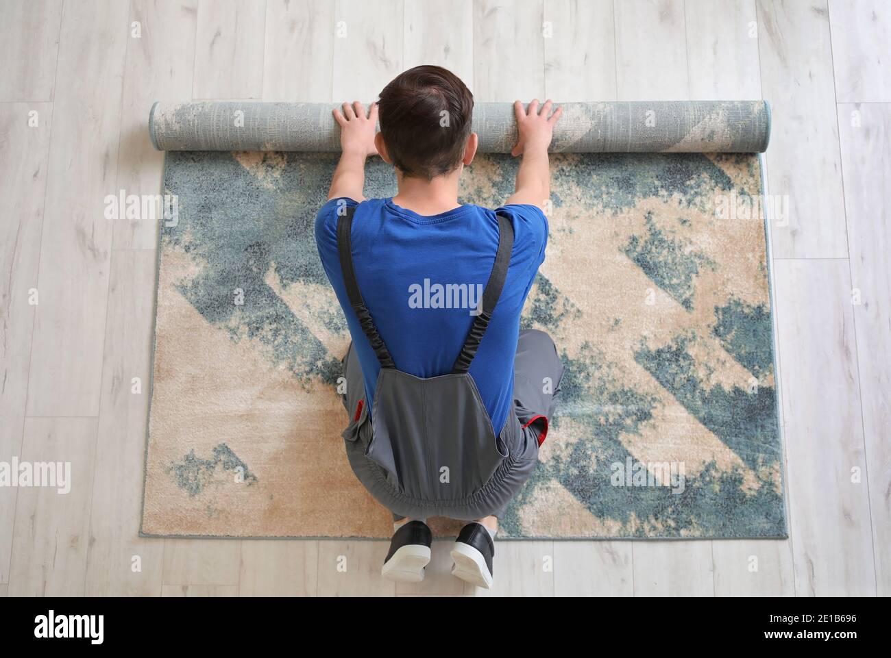 Male worker rolling carpet hi-res stock photography and images - Alamy