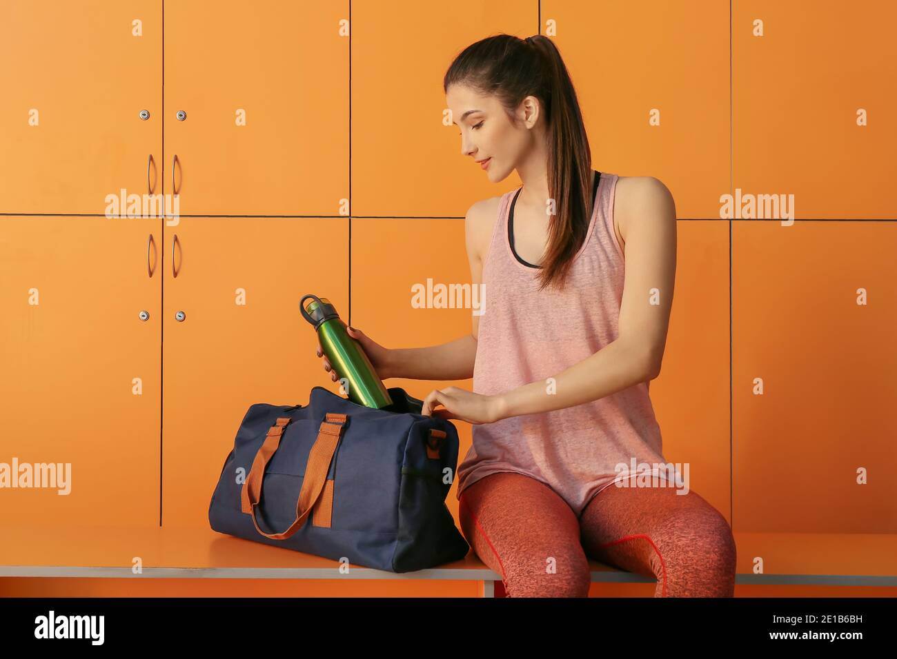Woman with sport bag in gym locker room Stock Photo - Alamy