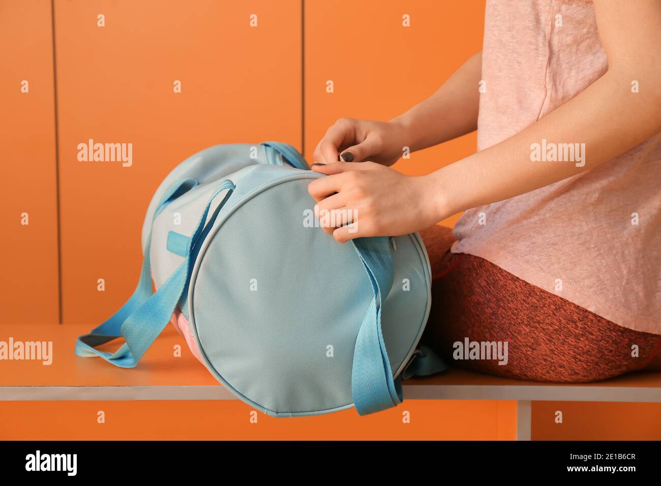 Woman with sport bag in gym locker room Stock Photo - Alamy