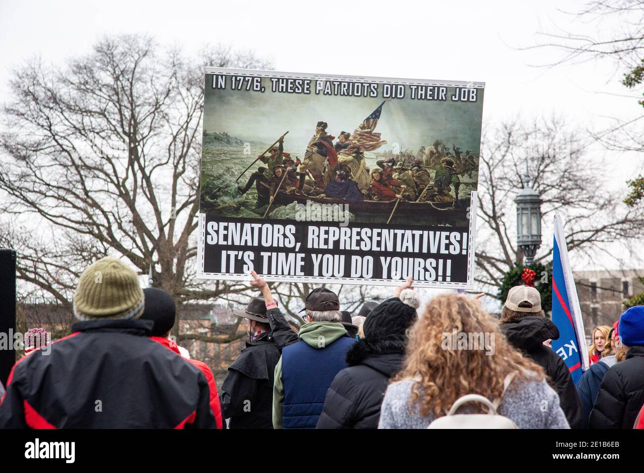 Protesters hold a large placard with an image of George Washington ...
