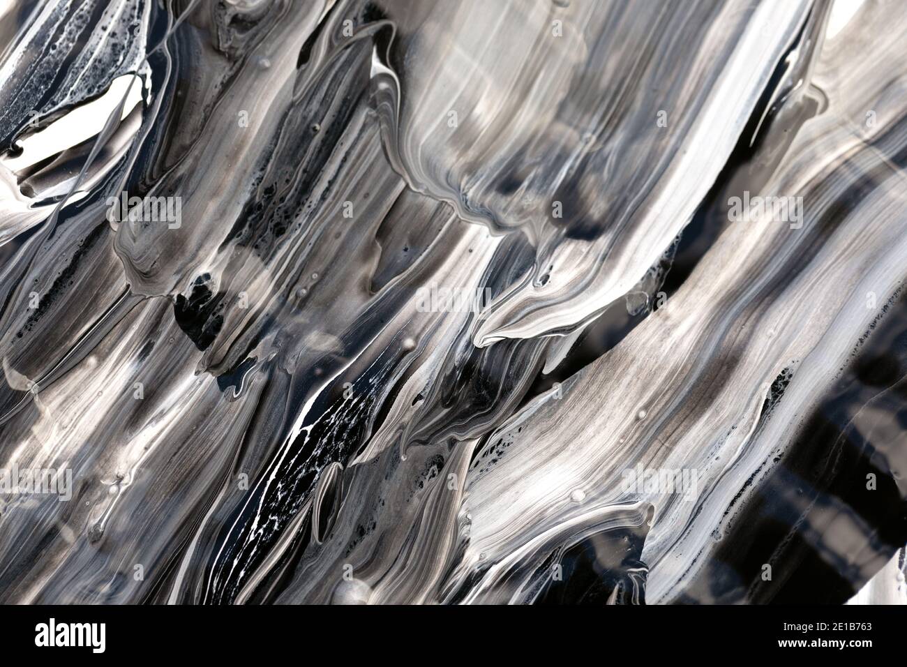 Drops of paint flowing on an inclined surface. Gray paint drips down ...