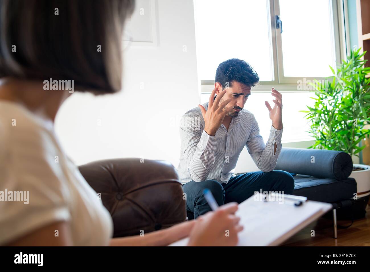 Psychologist taking notes during therapy session Stock Photo - Alamy