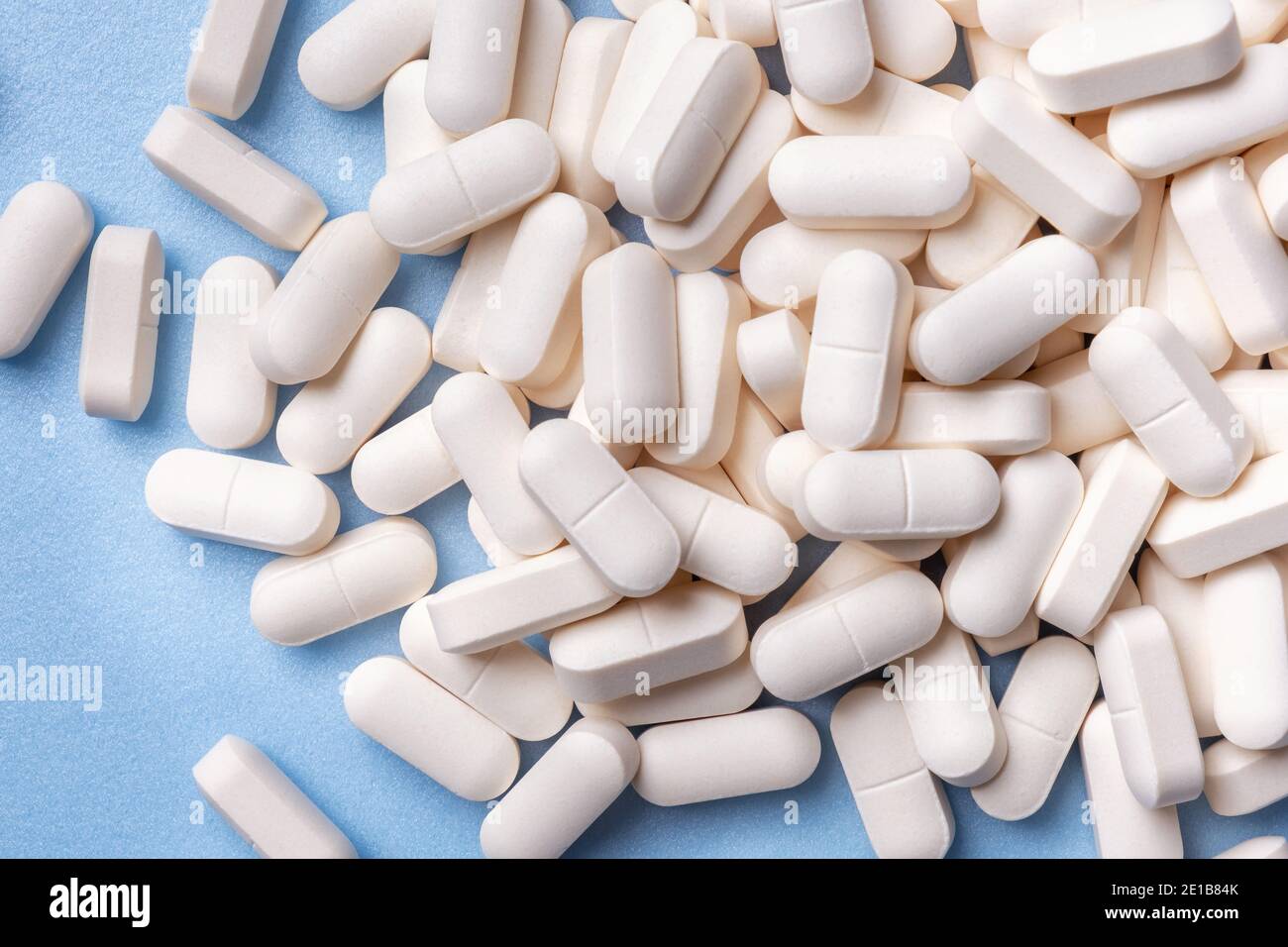 Medicine blue background from bunch white pills, macro. Drug production ...