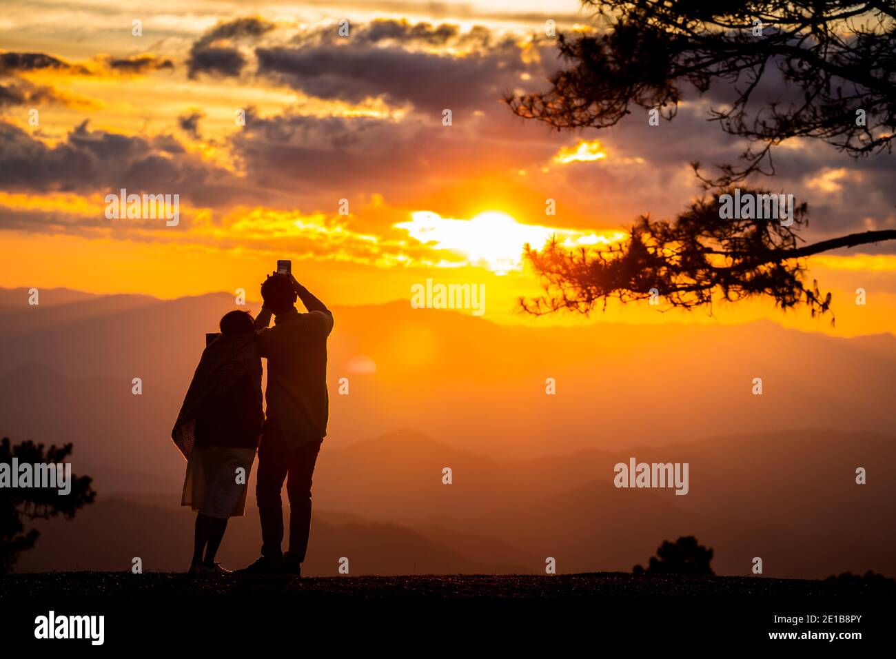 Couple in silhouette photograph mountain range view with orange light ...