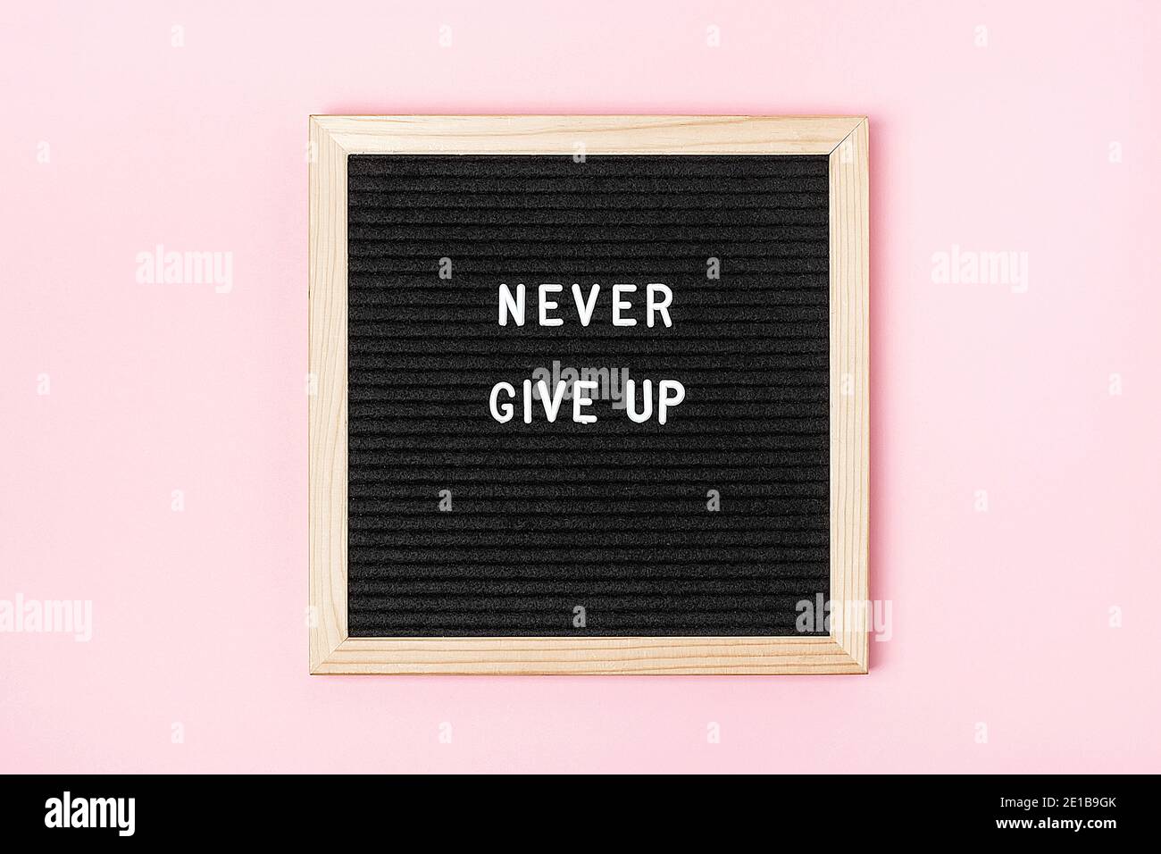 Never give up Motivational quote on black letter board on pink ...