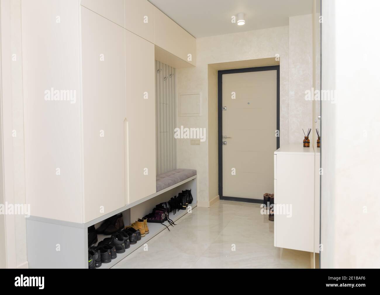 Beautiful modern entrance hall in light, white colors with a wardrobe ...