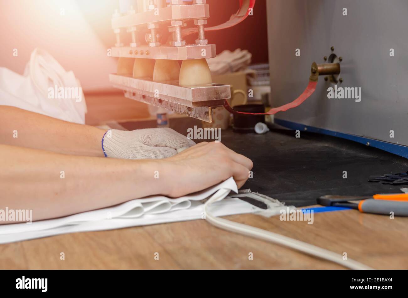 Men's hands work at the machine for welding PVC film and edging seam ...