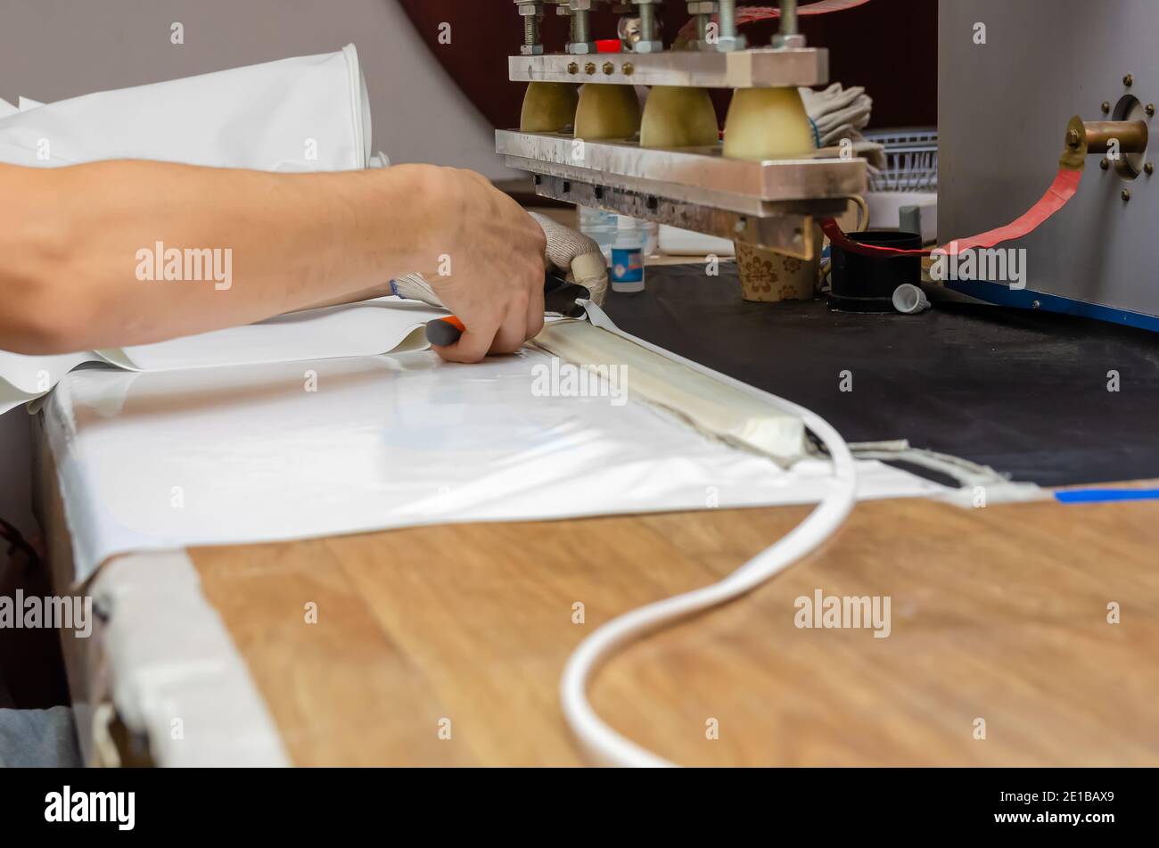 Men's hands work at the machine for welding PVC film and edging seam ...