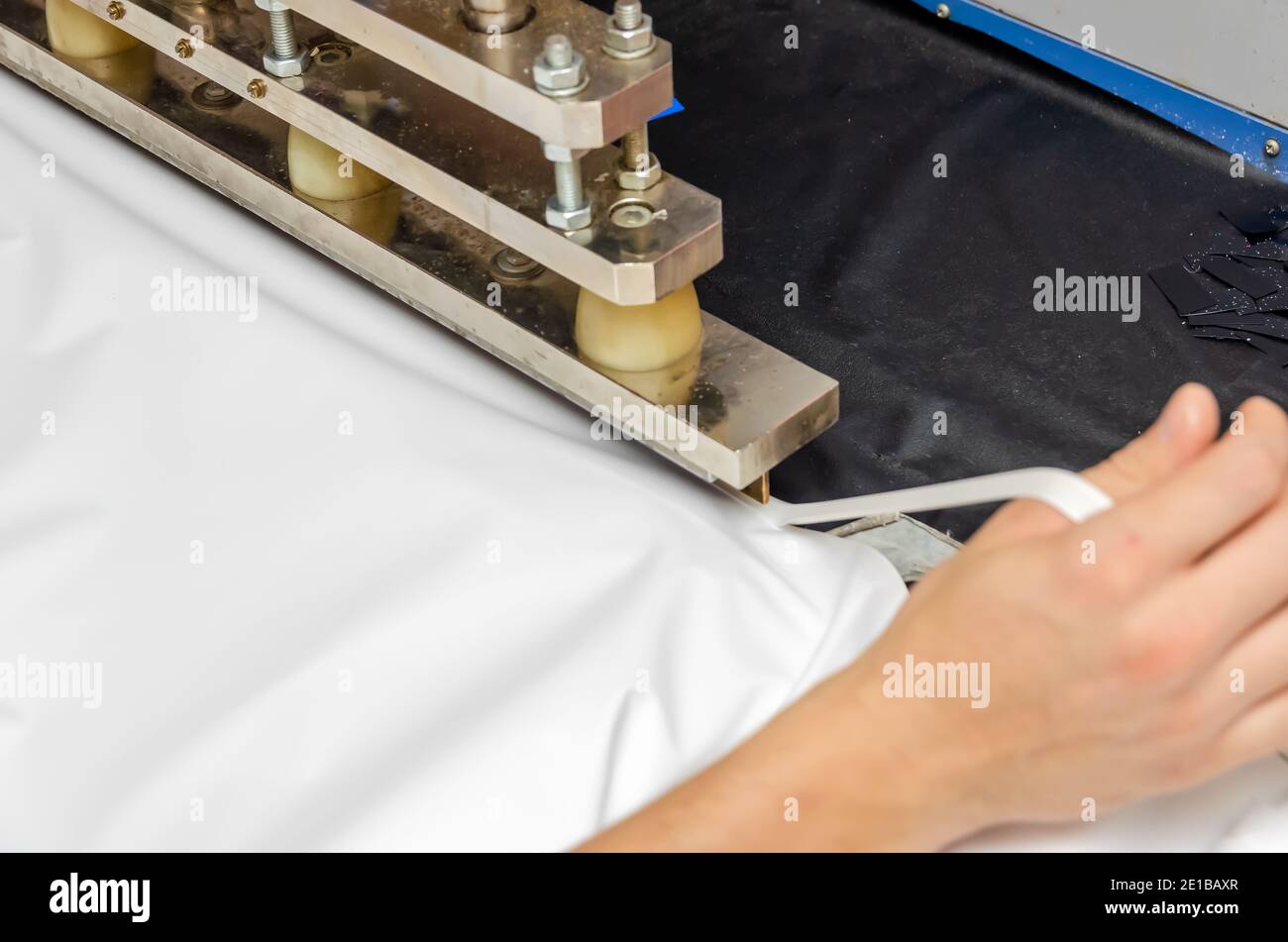 Men's hands work at the machine for welding PVC film and edging seam ...