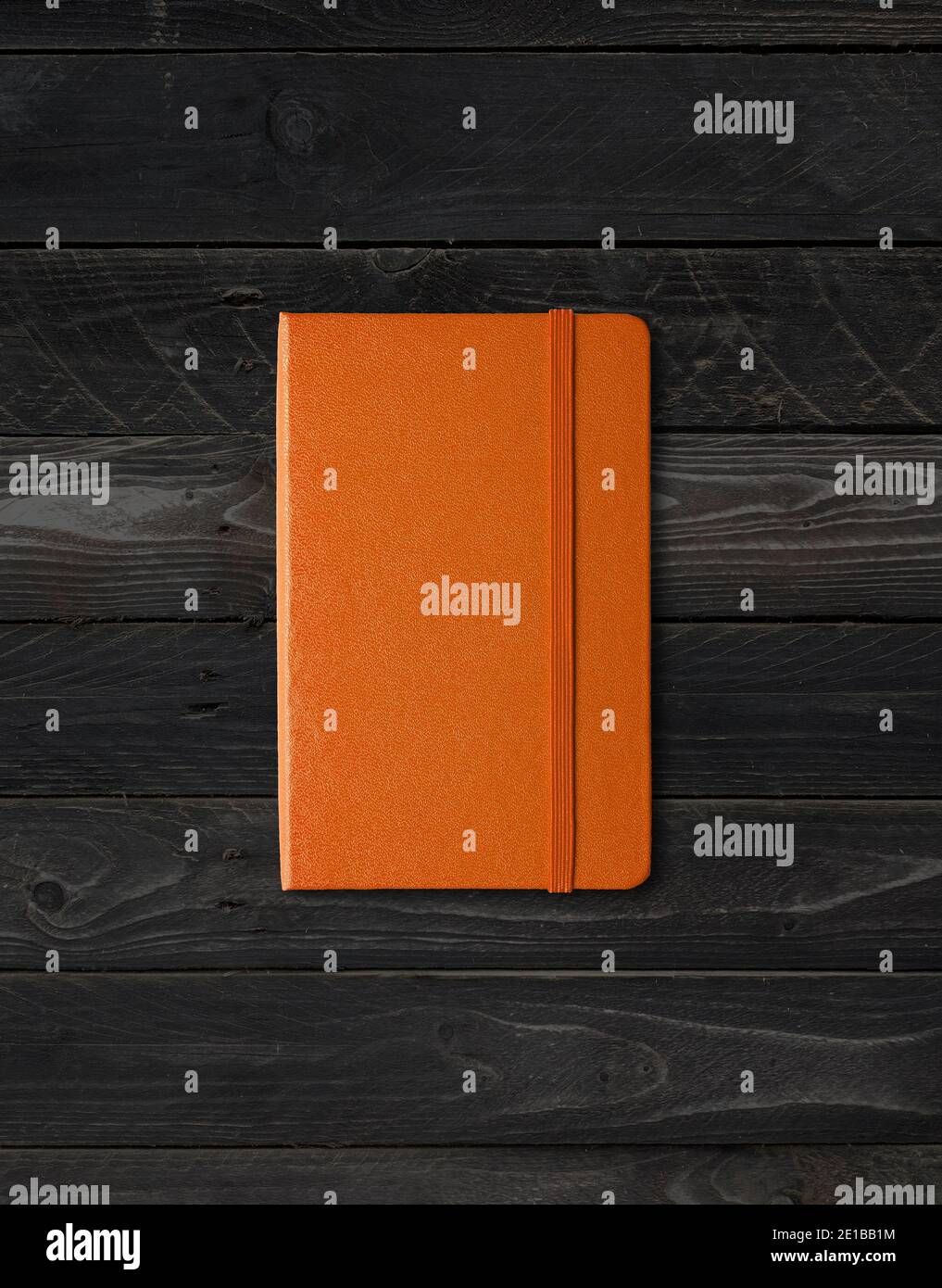 Orange closed notebook mockup isolated on black wood background Stock ...