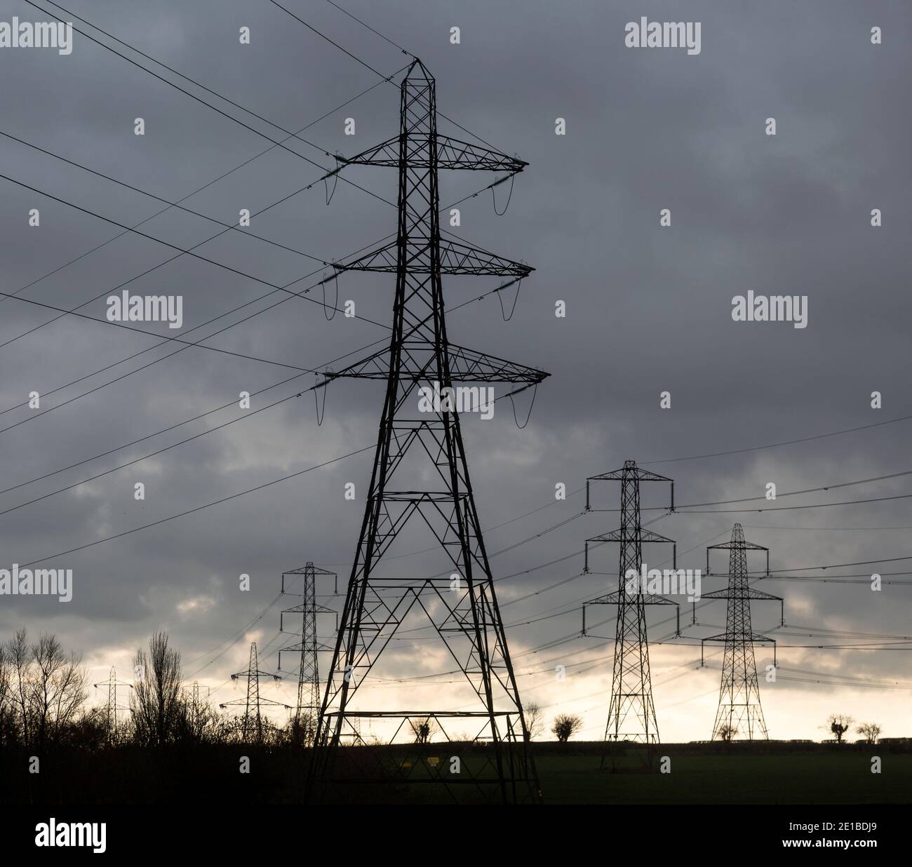 Electricity power lines and pylons crossing countryside very overcast ...