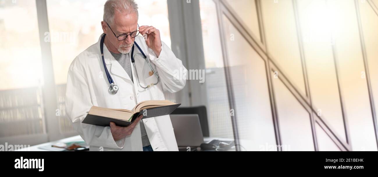 Senior doctor reading a textbook in clinic; multiple exposure Stock ...