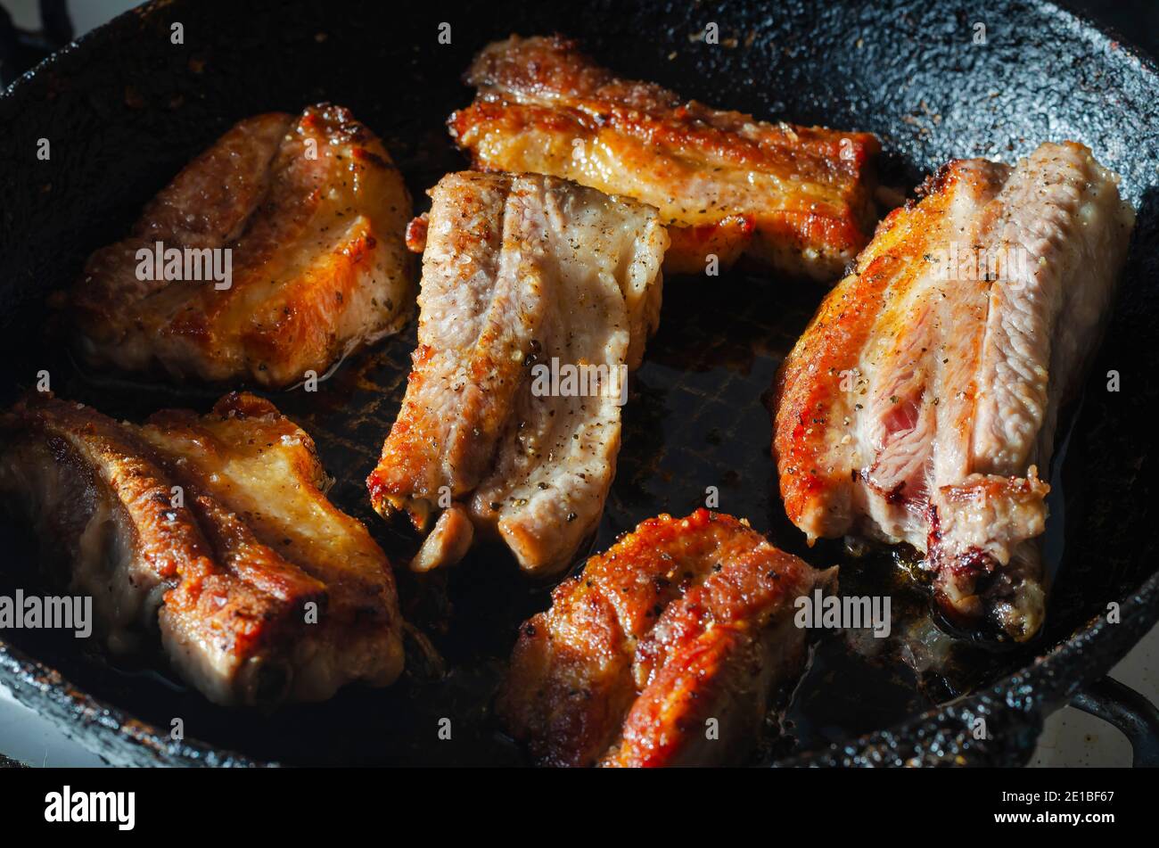 Fried pork ribs in a pan. Close-up of ready-to-eat chunks of grilled ...