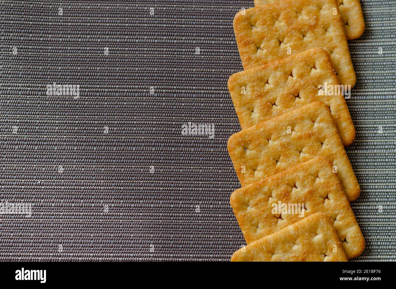 Groceries, snacks, food. Salted crispy crackers on a gray textured ...