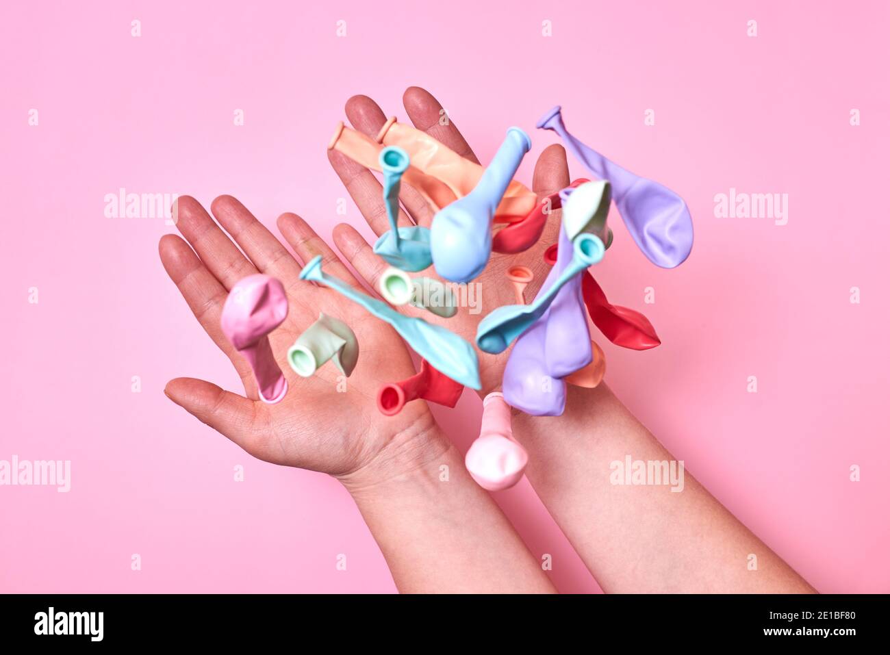 Multicolored not inflated balloons thrown into the air from the hands ...