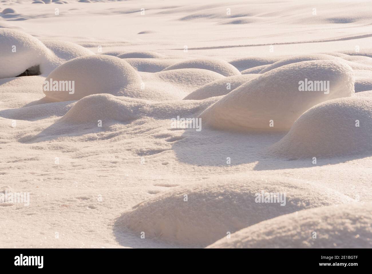 Smooth snow drifts on sunny winter day. Deep and high snow drifts ...